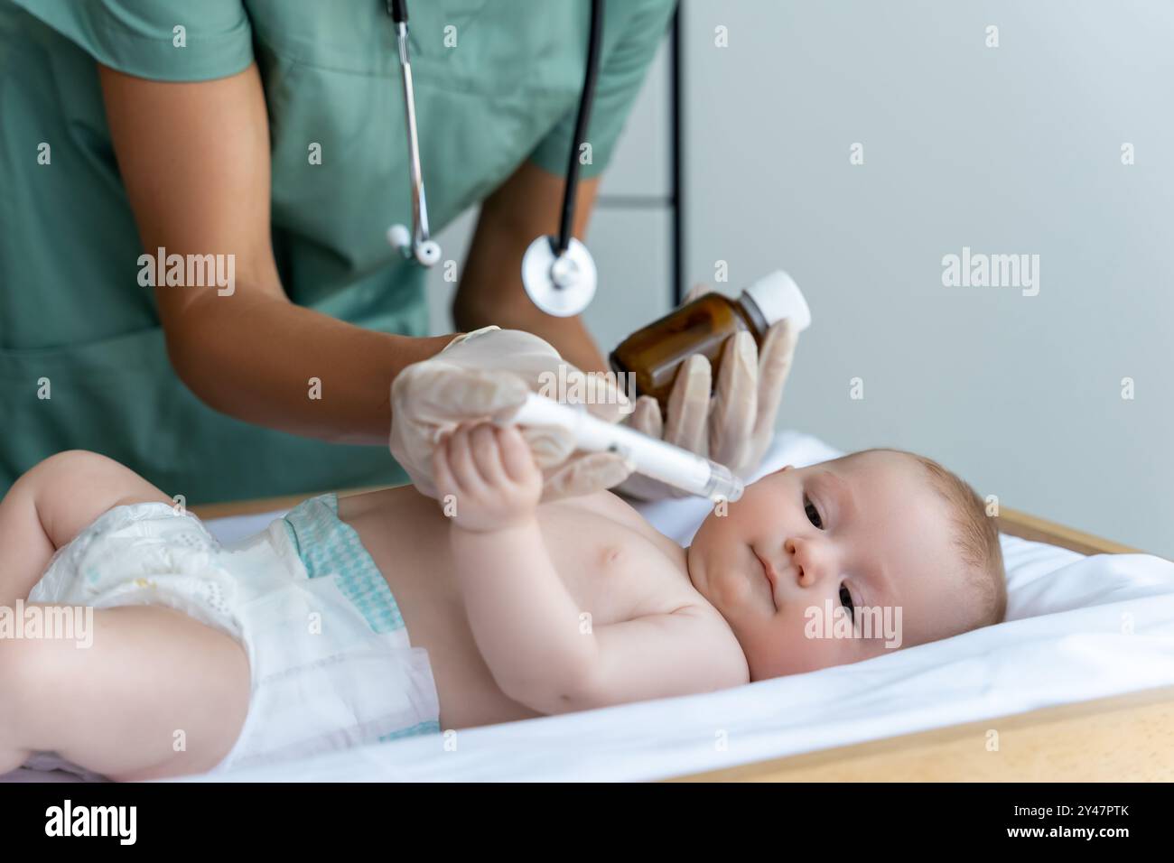 Doctor giving dose of syrup to sick baby in the clinic Stock Photo - Alamy