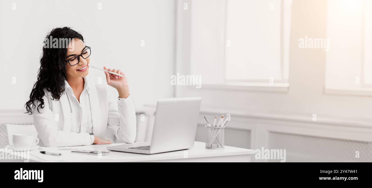 Satisfied mexican girl manager holding pen and dreaming Stock Photo - Alamy