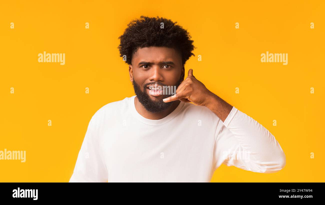 Single african guy making call me gesture Stock Photo - Alamy