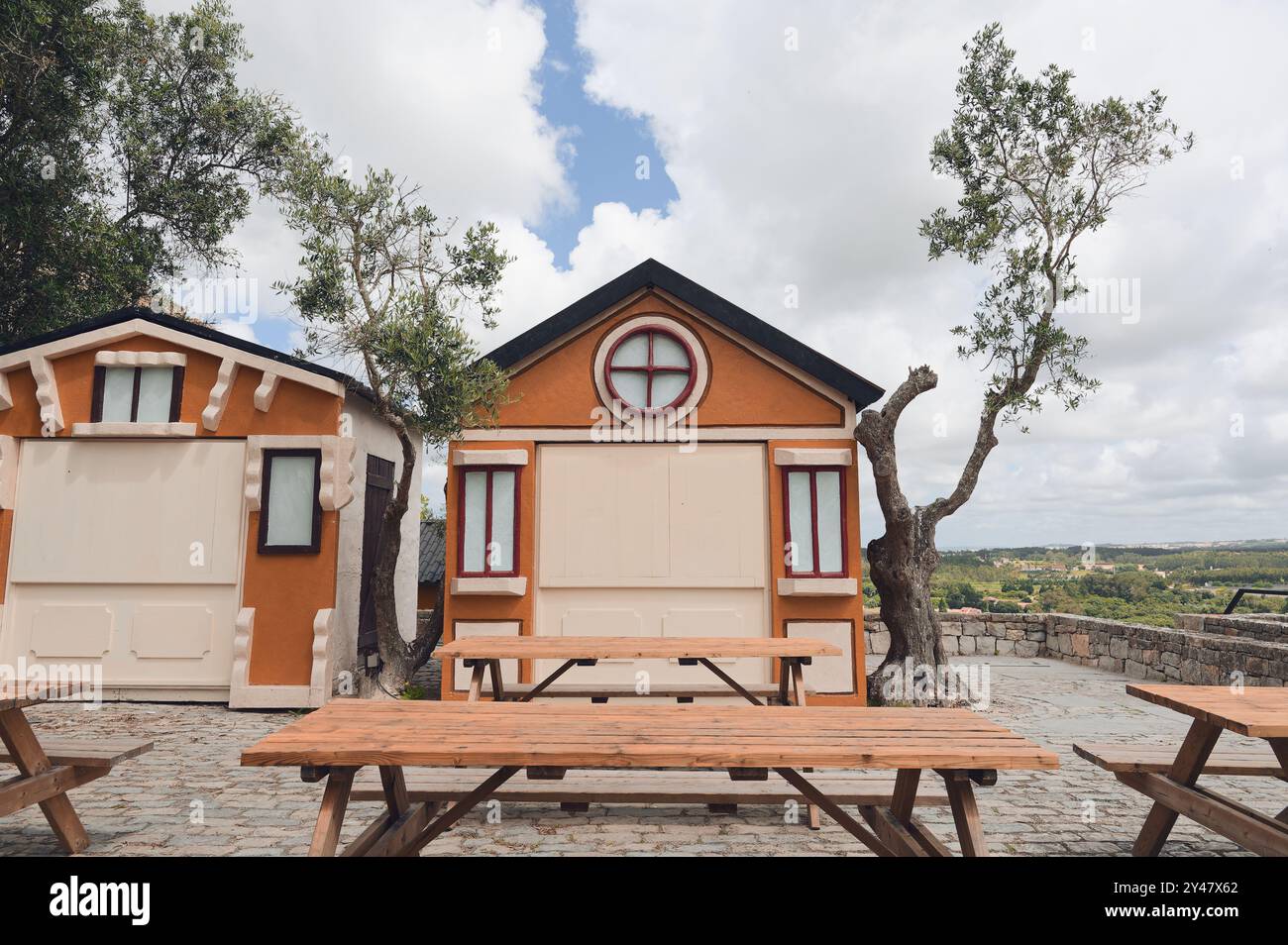 Rustic picnic setting outside colorful cottages under a bright sky ...