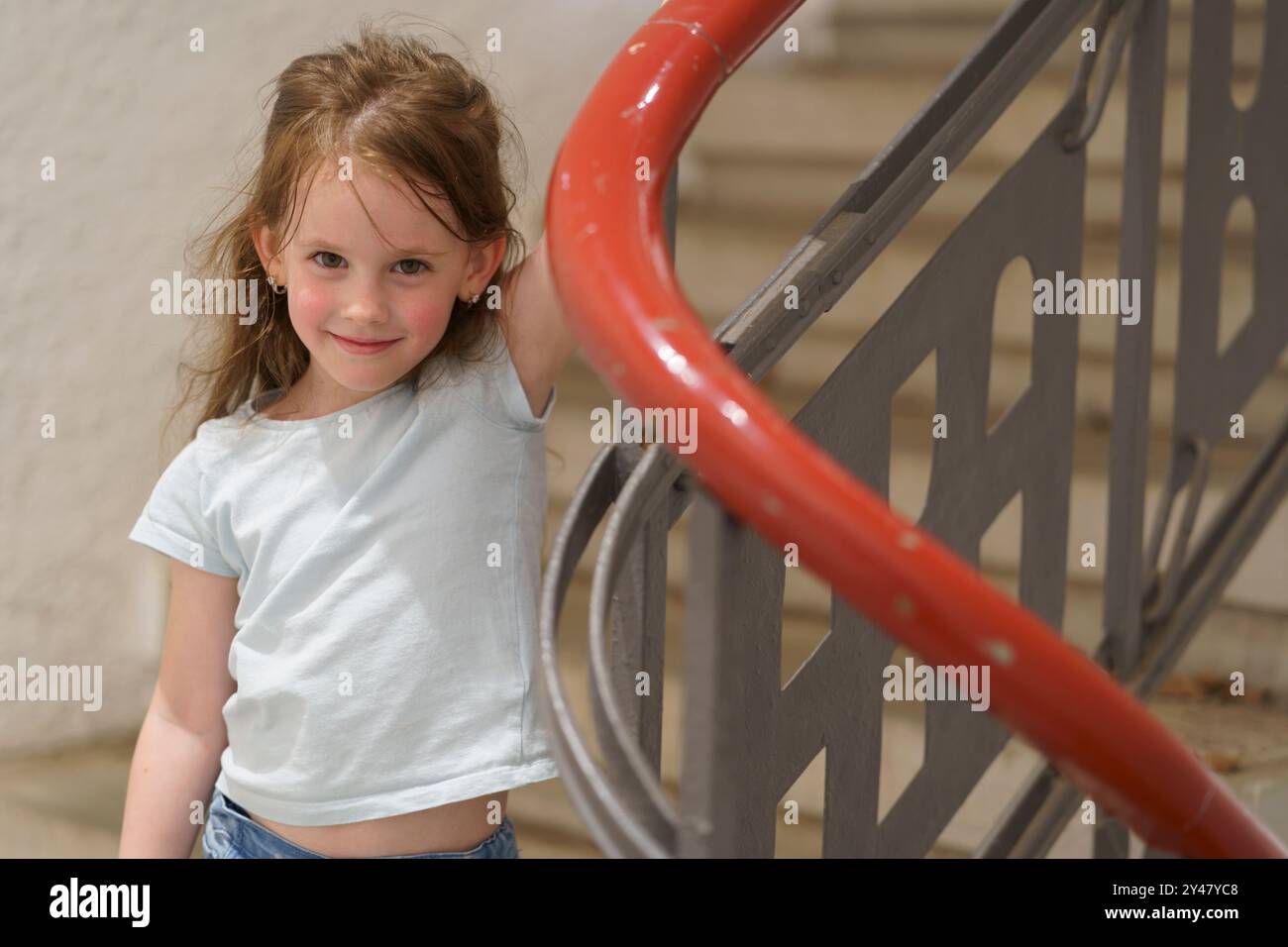 Little cute girl walking on stairs holding handrail. Children's ...