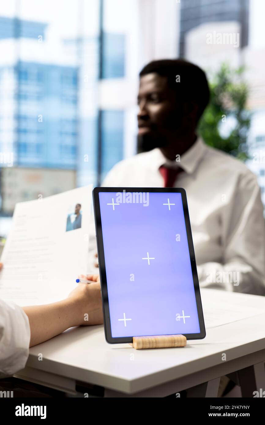 HR specialist using isolated screen tablet to reviewing candidate CV, asking questions about ...
