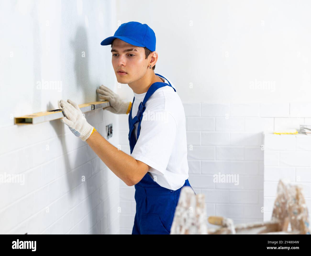 Worker checking level laying tiles hi-res stock photography and images ...