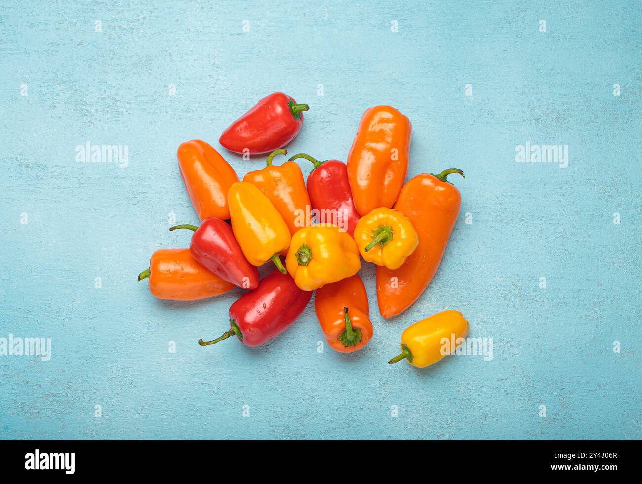 Sweet mini peppers lying on a blue tabletop Stock Photo - Alamy