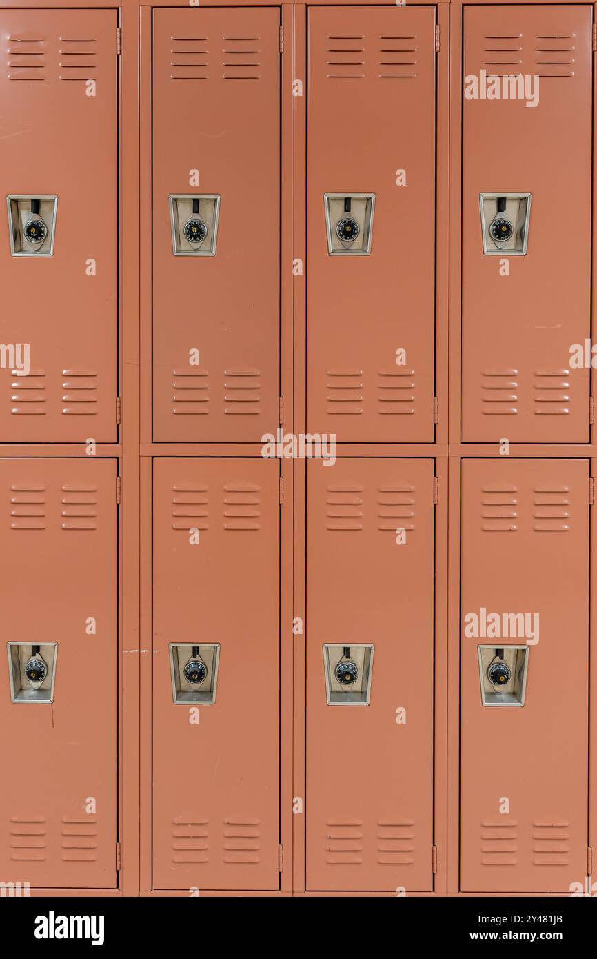 Vertical image, light orange to pink, salmon color metal locker along a ...