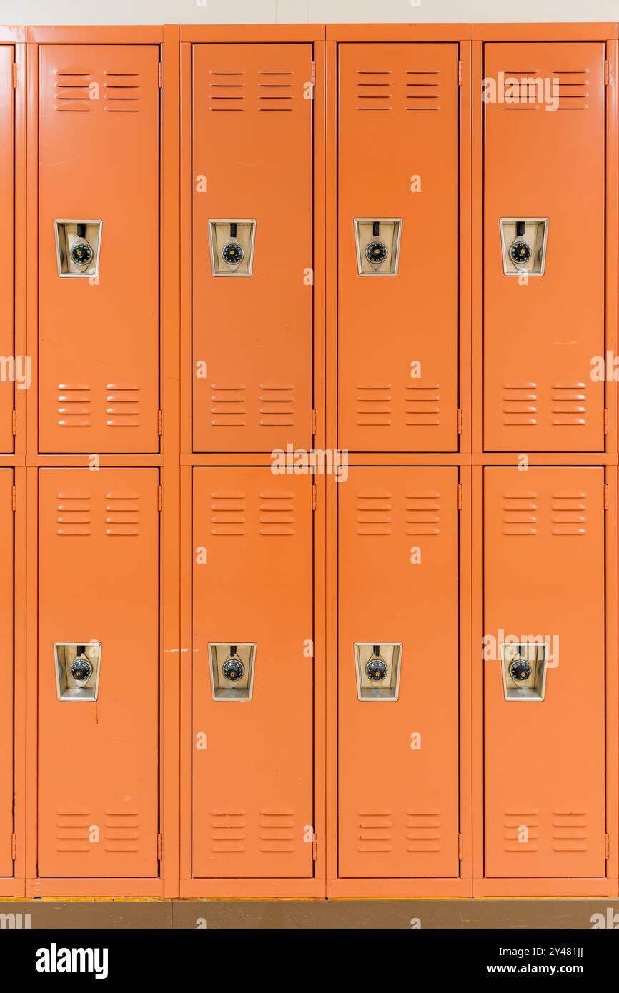 Vertical image, light orange to pink, salmon color metal locker along a ...