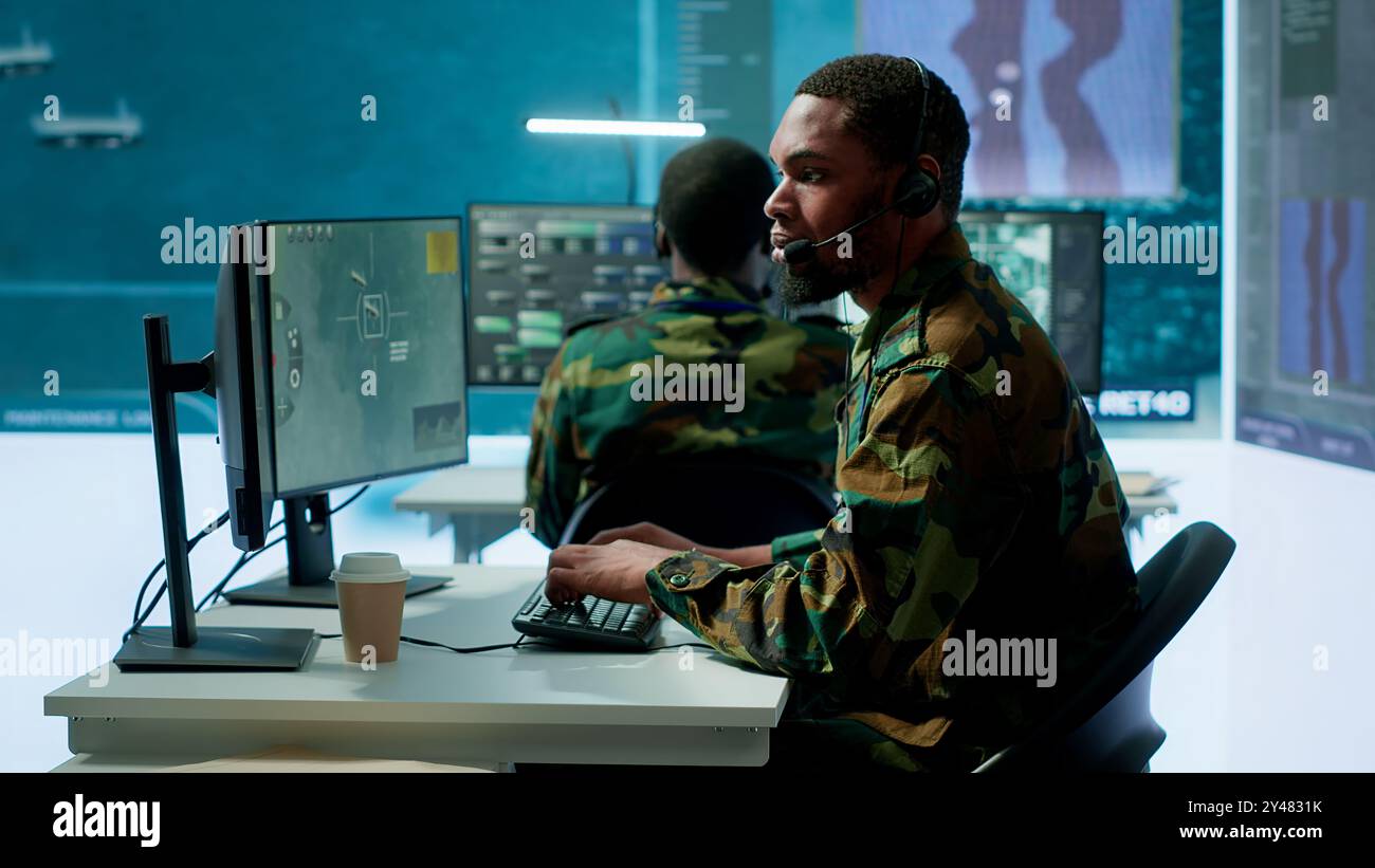 Soldiers in a state of the art military control room collaborate on data analysis, intelligence ...