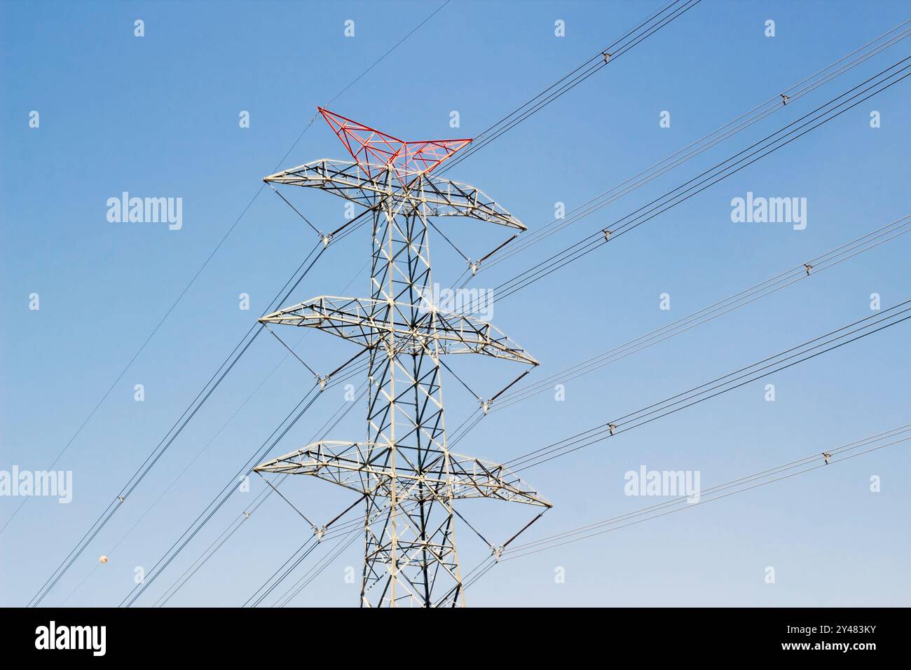 Close-up taken of a concrete electric pole with steel cables in blue ...