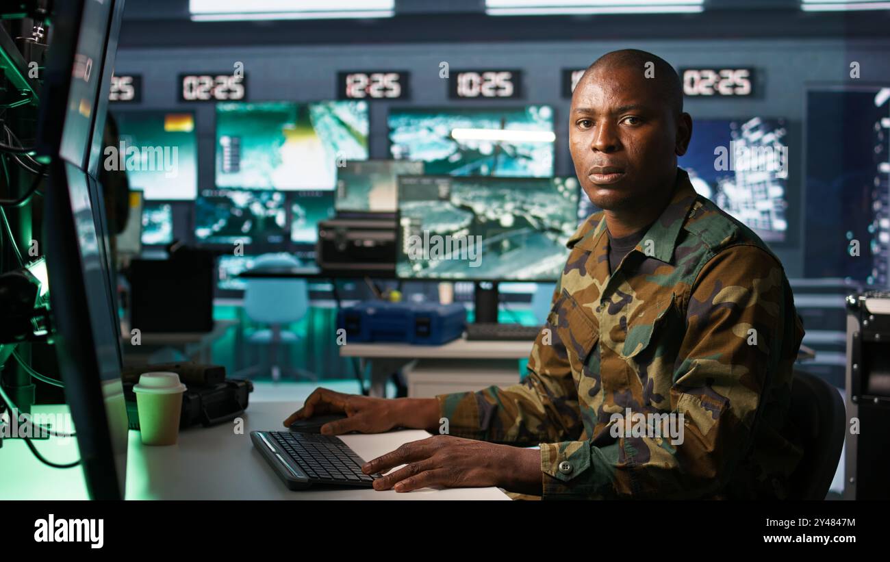 Portrait of military agent working in control room, analyzing aerial ...