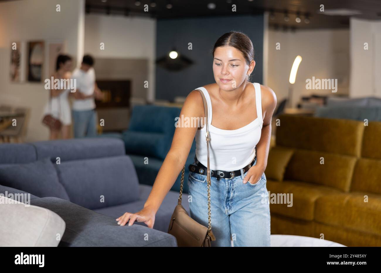 Portrait of woman consumer choosing modern sofa in furniture shop Stock ...