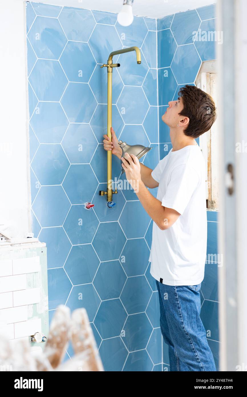 Guy installing shower in bathroom in house under renovation Stock Photo ...