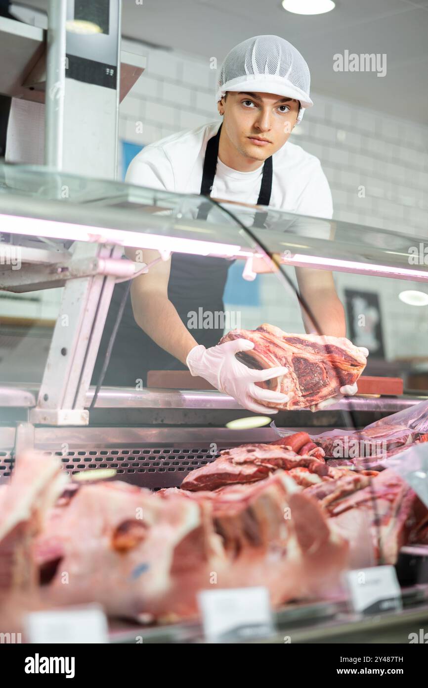 Guy seller works in specialized butcher shop Stock Photo - Alamy