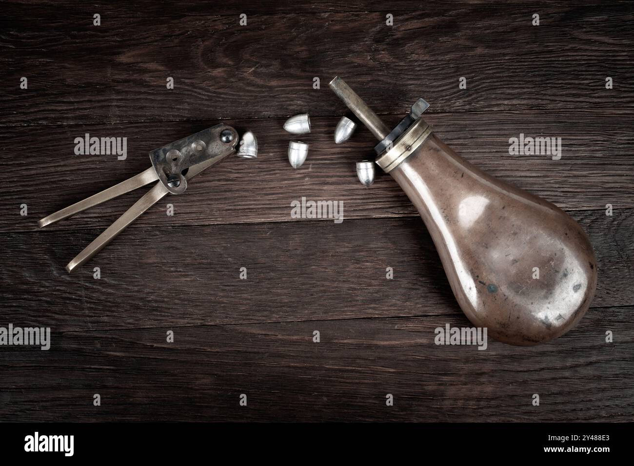 old west bullet mold with bullets and powder flask on wood deck ...