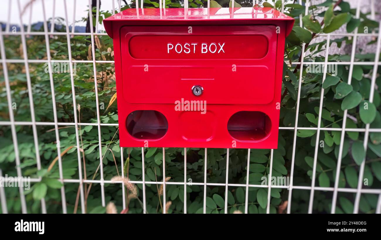 red post box on the fence Stock Photo - Alamy