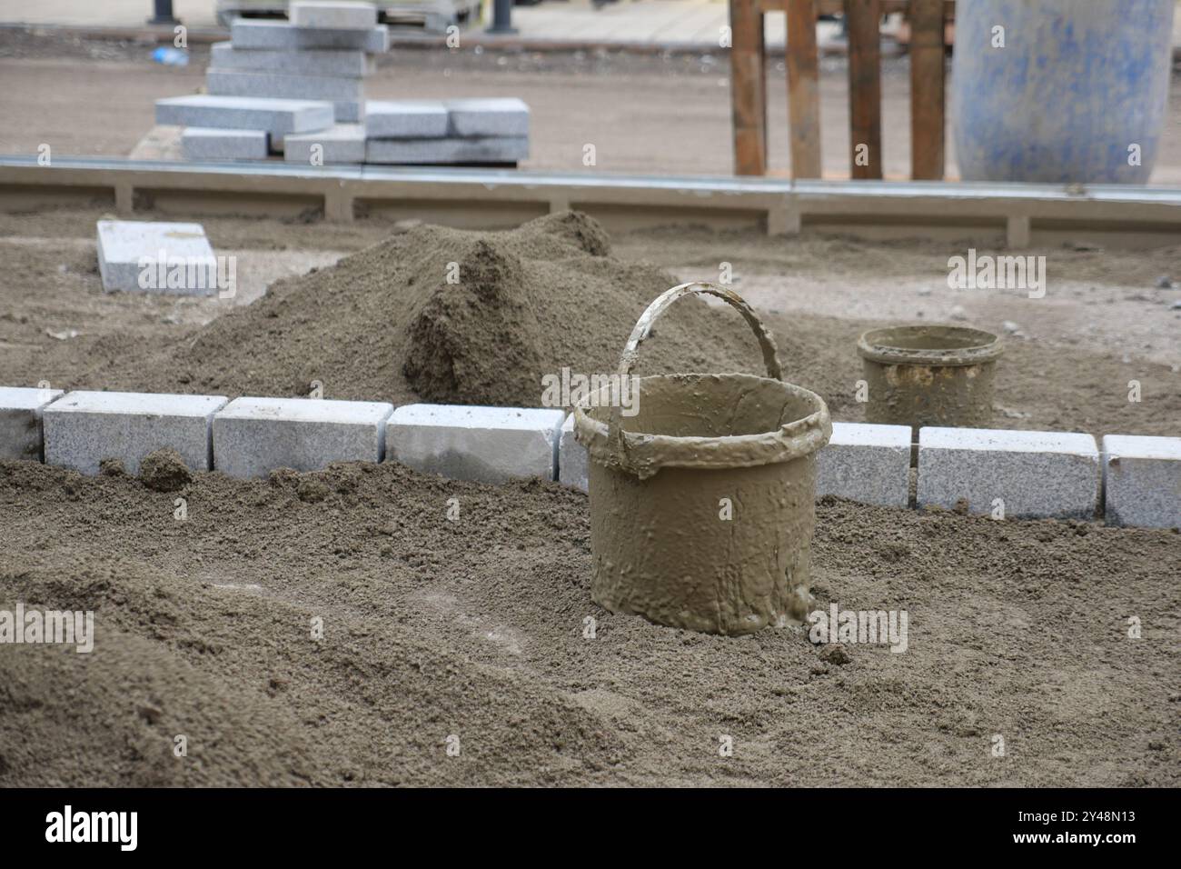 A bustling construction site showcasing buckets and bricks situated on ...