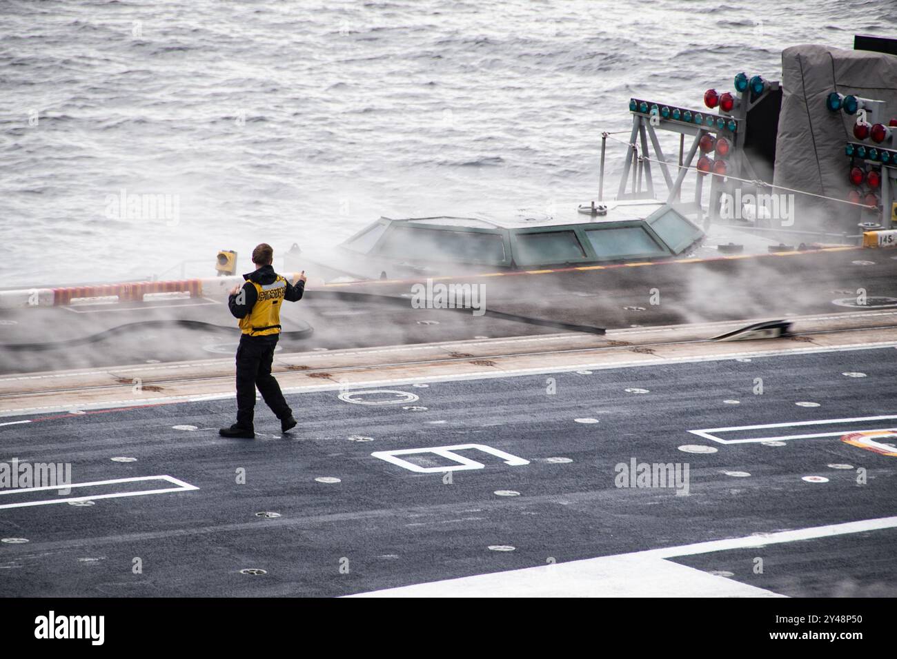 A Sailor supervises catapult preparations on the flight deck of the ...