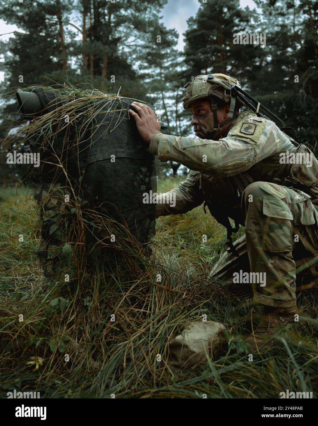 A U.S. Army paratrooper with the 173rd Airborne Brigade aims with the ...
