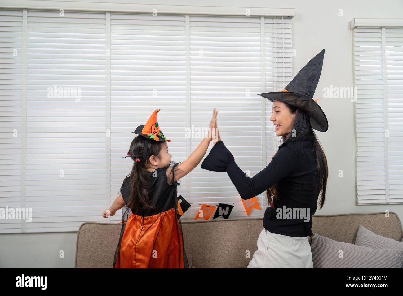 Mother and Daughter Sharing a High Five During Halloween Stock Photo ...
