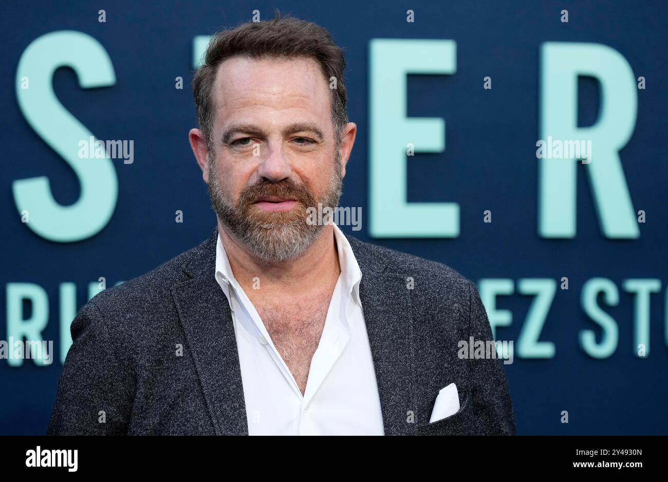 Paul Adelstein poses at the premiere of the Netflix series "Monsters ...