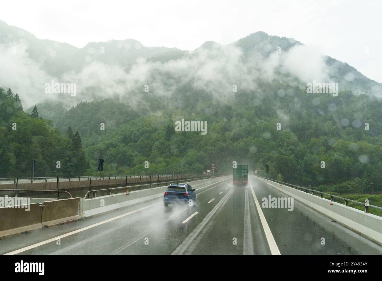 Heavy rain falls on a mountain highway, creating hazardous driving ...