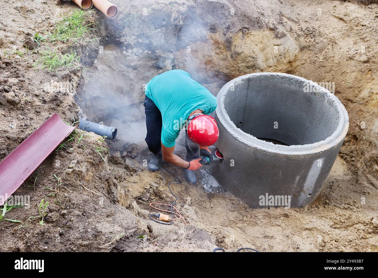 Using diamond blade to cut hole for inlet pipe in concrete ring of ...