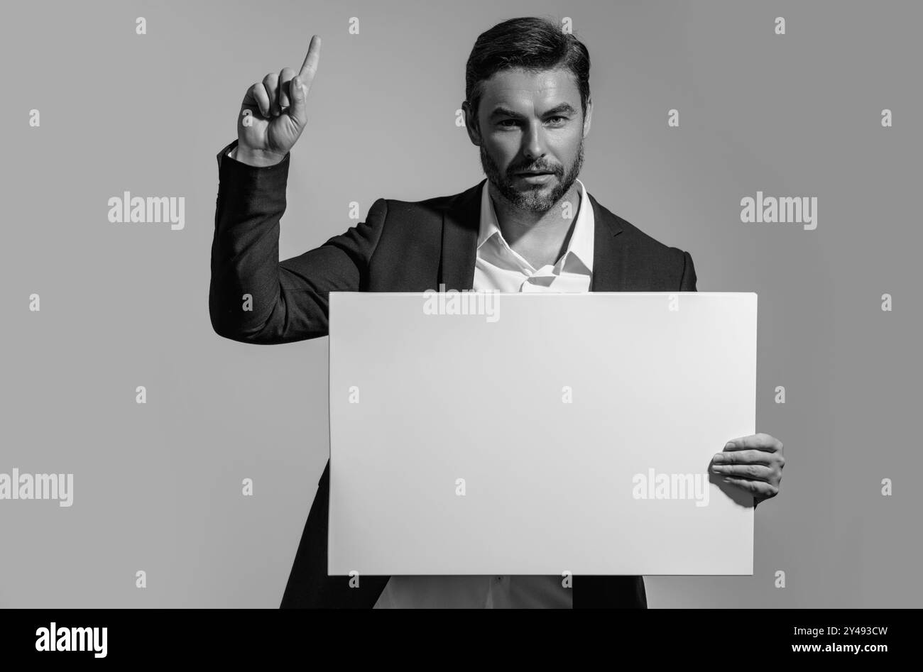 Happy man hold board thinking of idea on studio background. Portrait of ...