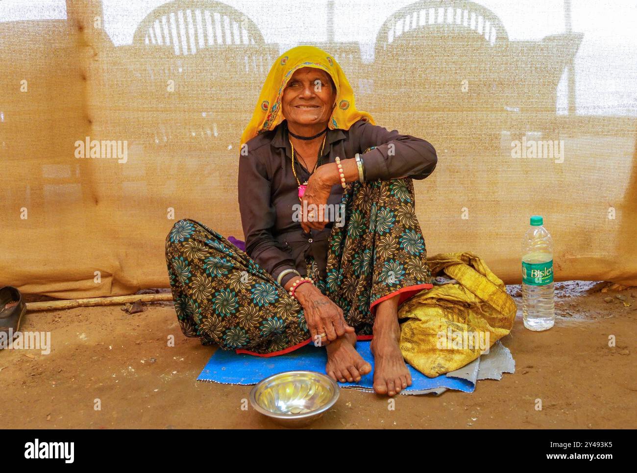 GOA, India - February 22, 2024: A poor woman collects alms sitting on ...