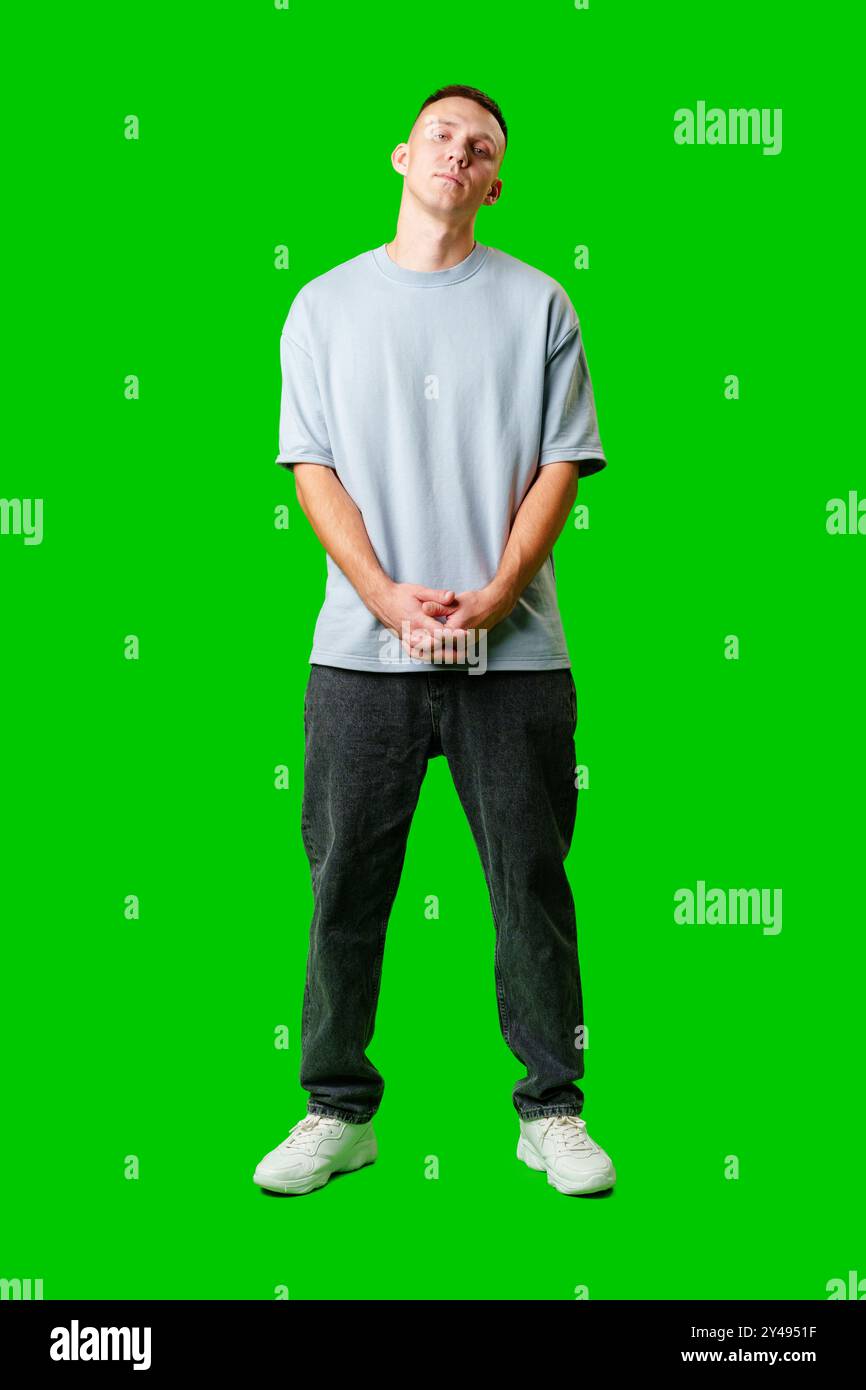 Young Man Standing Confidently Against Bright Green Background in ...