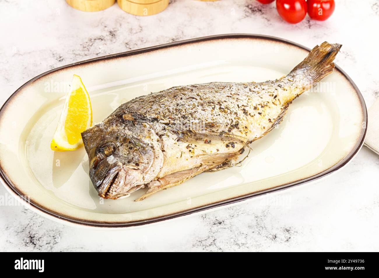 Baked Dorado fish served lemon slice Stock Photo - Alamy