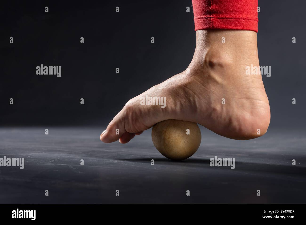 Myofascial release of foot muscles with a massage ball on a dark ...