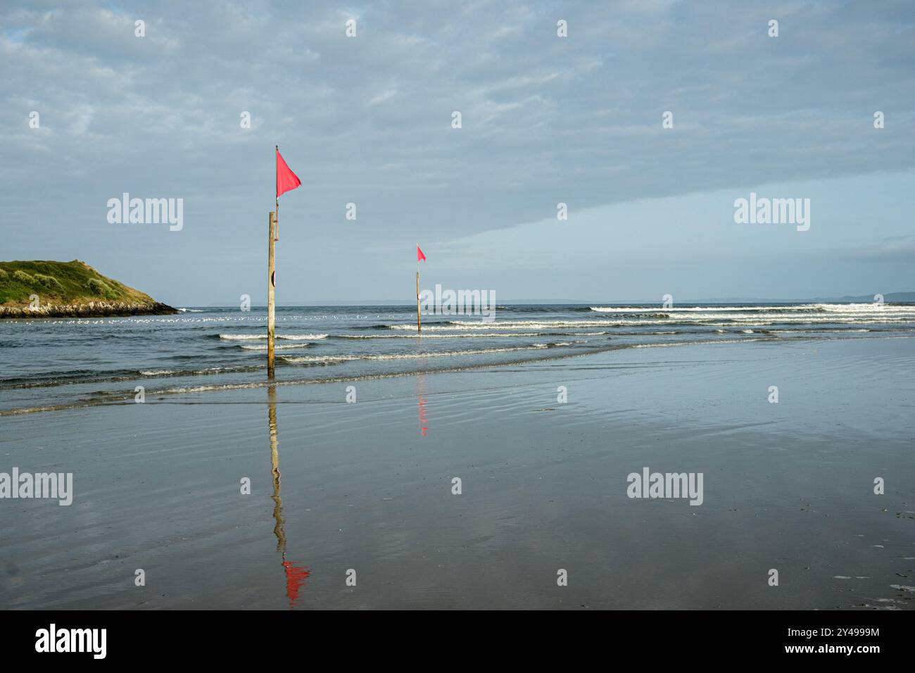 Red flags at the edge of the ocean indicating that swimming is ...
