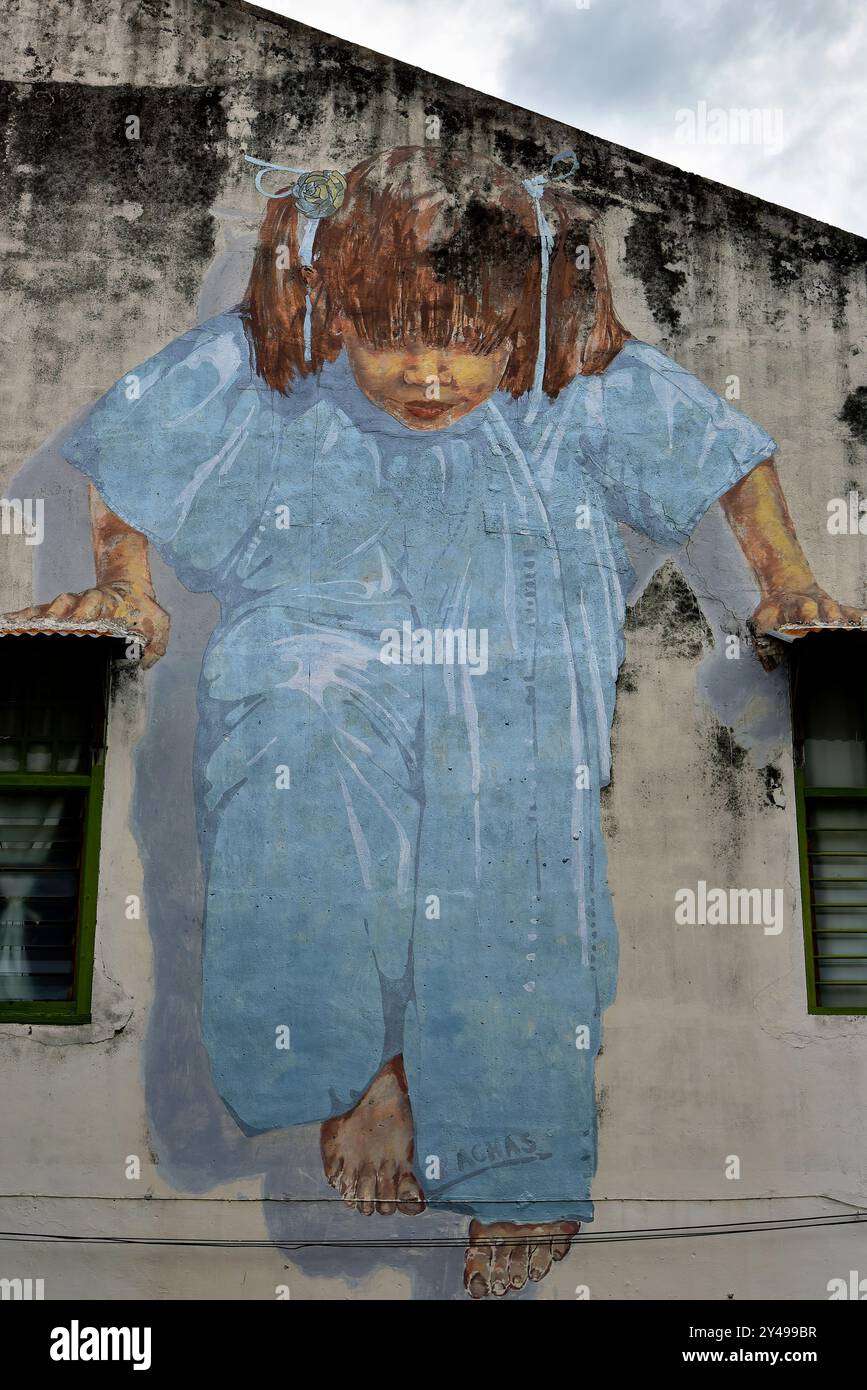 Playful murals and street art of George Town, Penang, Malaysia. Child in blue pajamas supported ...