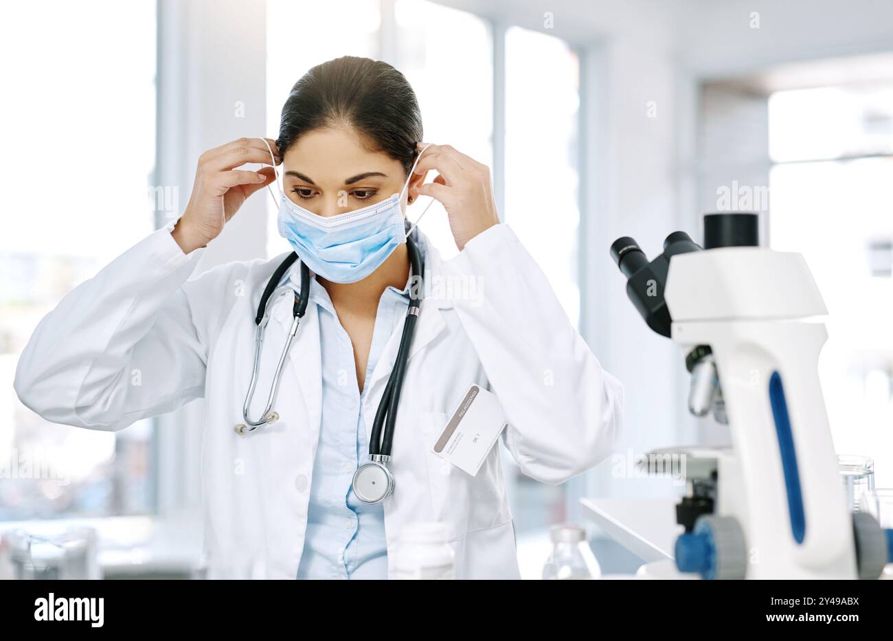 Woman, doctor and mask with microscope for biology, forensic science or ...