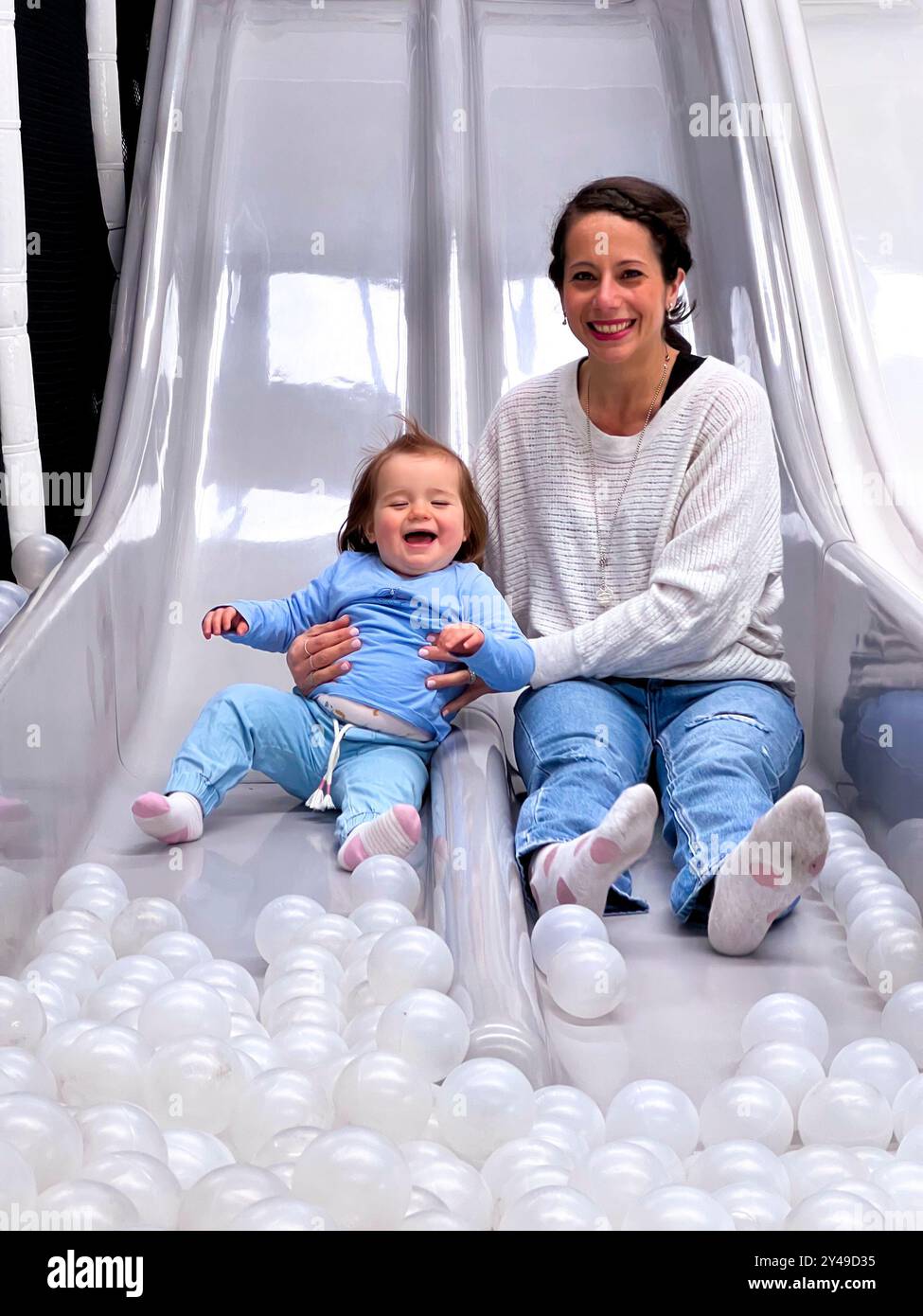 A mother and her young child enjoying a fun time at an indoor ...