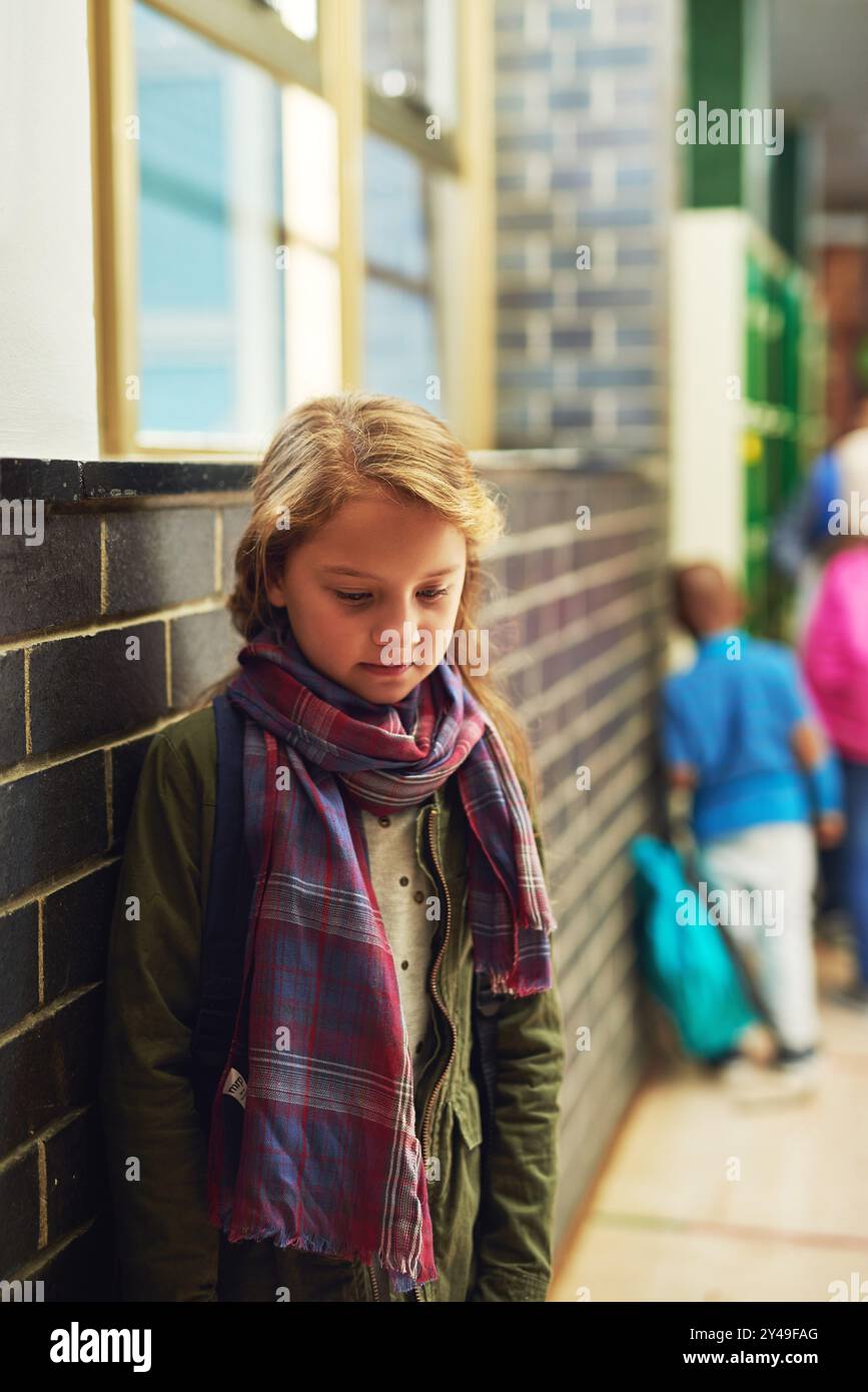 Bullying, thinking or lonely girl student in hallway of school alone ...