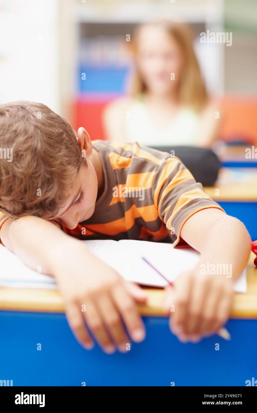 Sleeping, boy and student in classroom, tired and fatigue with homework, notebook and stress ...