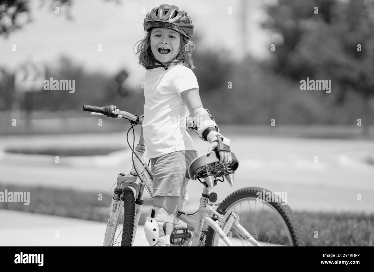 Kid riding bike in a helmet. Child with a childs bike and in protective ...