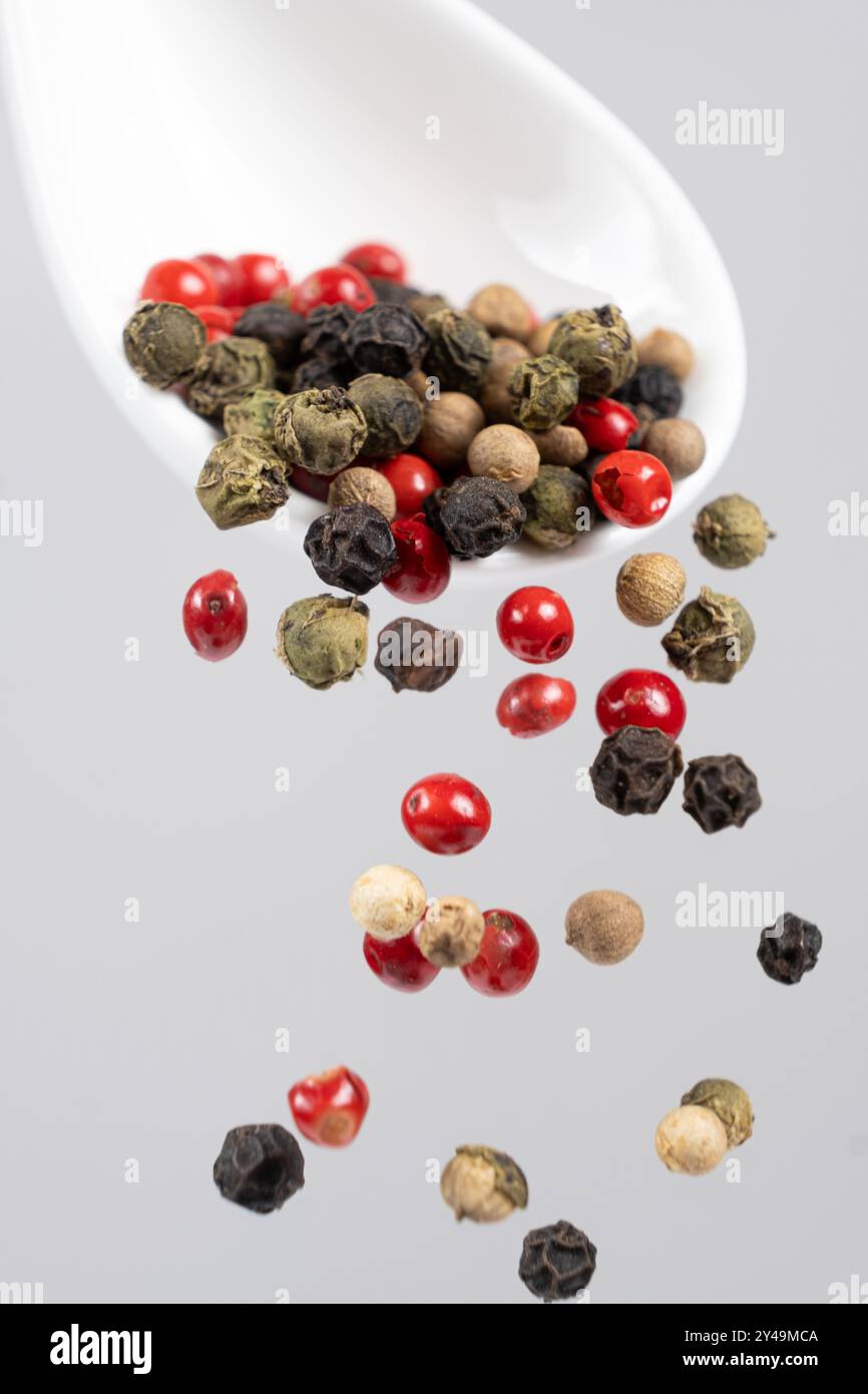 Different types of peppercorns pouring. Red, green, white and black ...