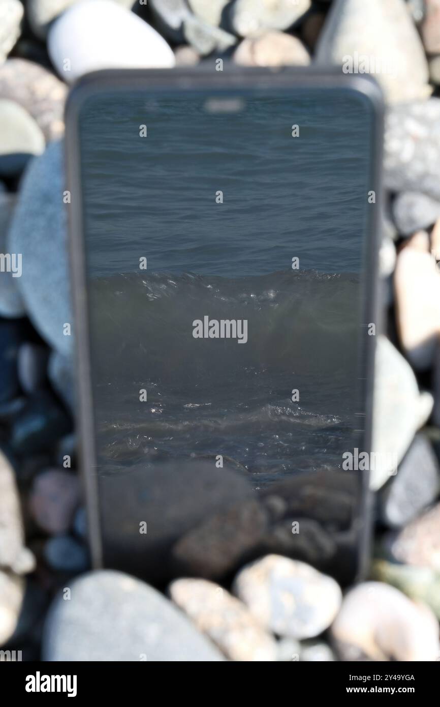 Mobile phone with a black screen on a background of sea pebbles Stock ...