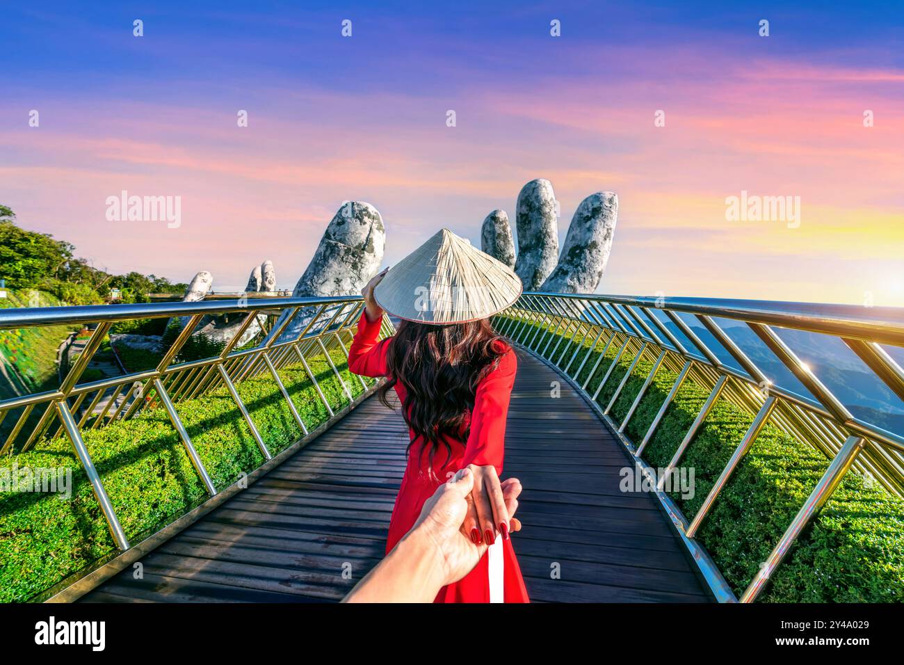 Women tourist holding man's hand and leading him to Golden bridge in Da ...