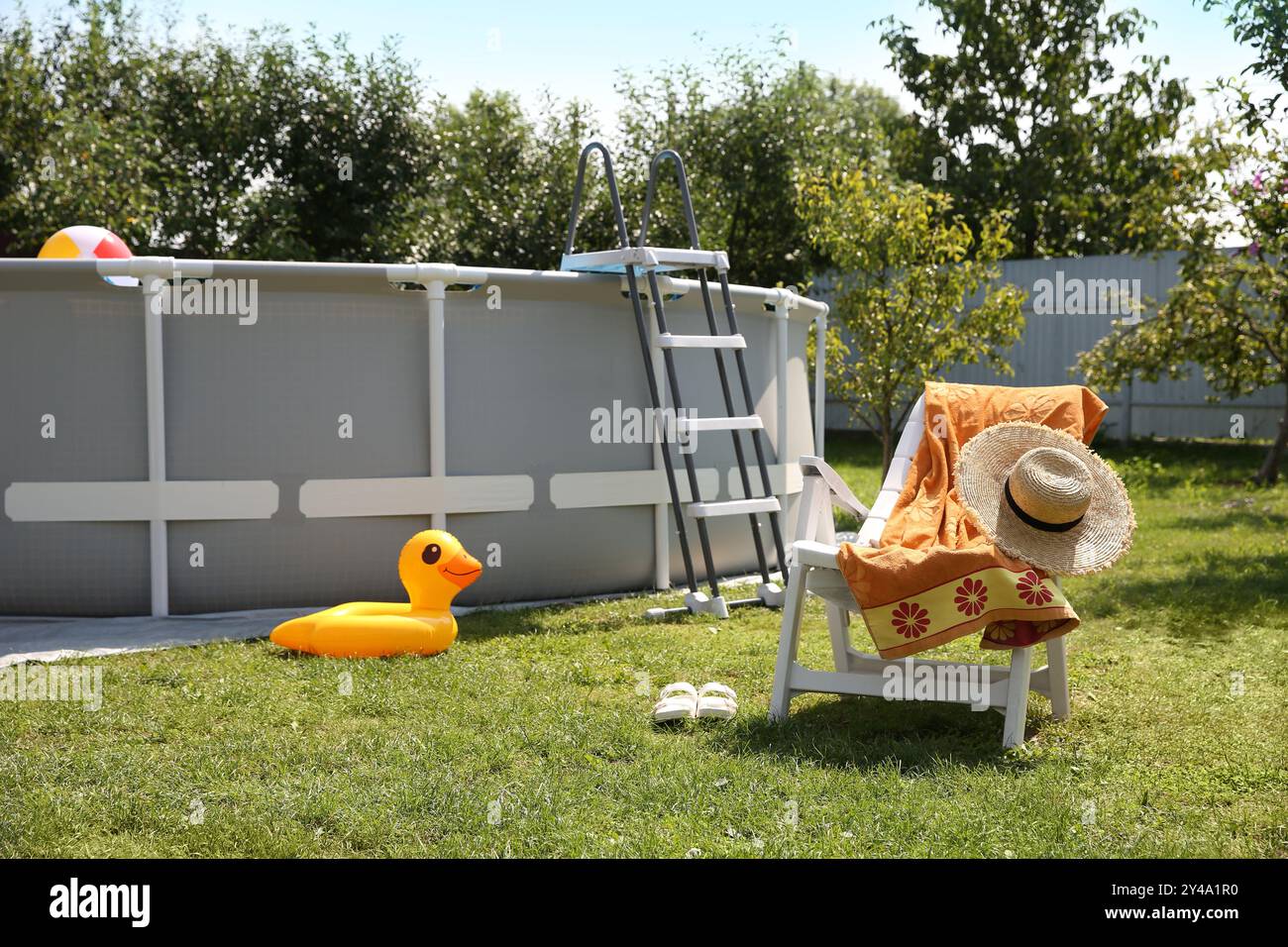 Above ground swimming pool, folding chair, towel, inflatable ring and ...
