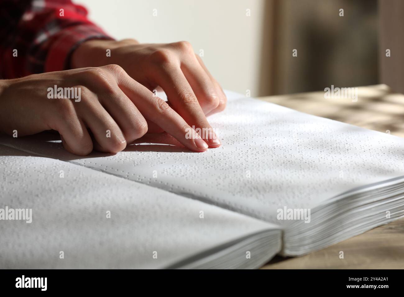 Blind woman reading book written in Braille at table, closeup Stock ...