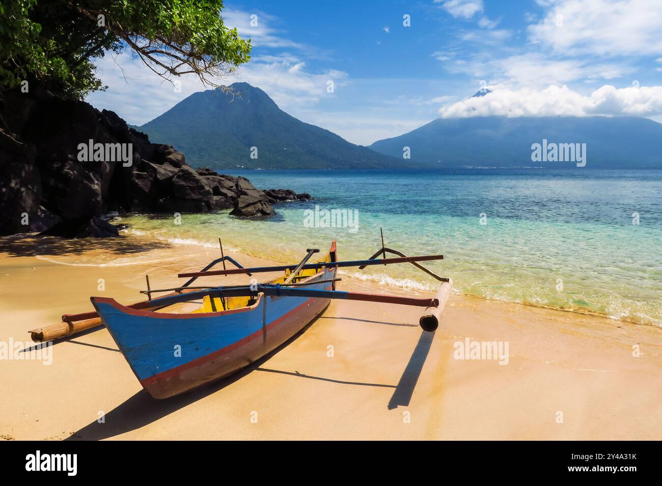 Outrigger canoe moored on beautiful Kalea Beach with Karangetang ...