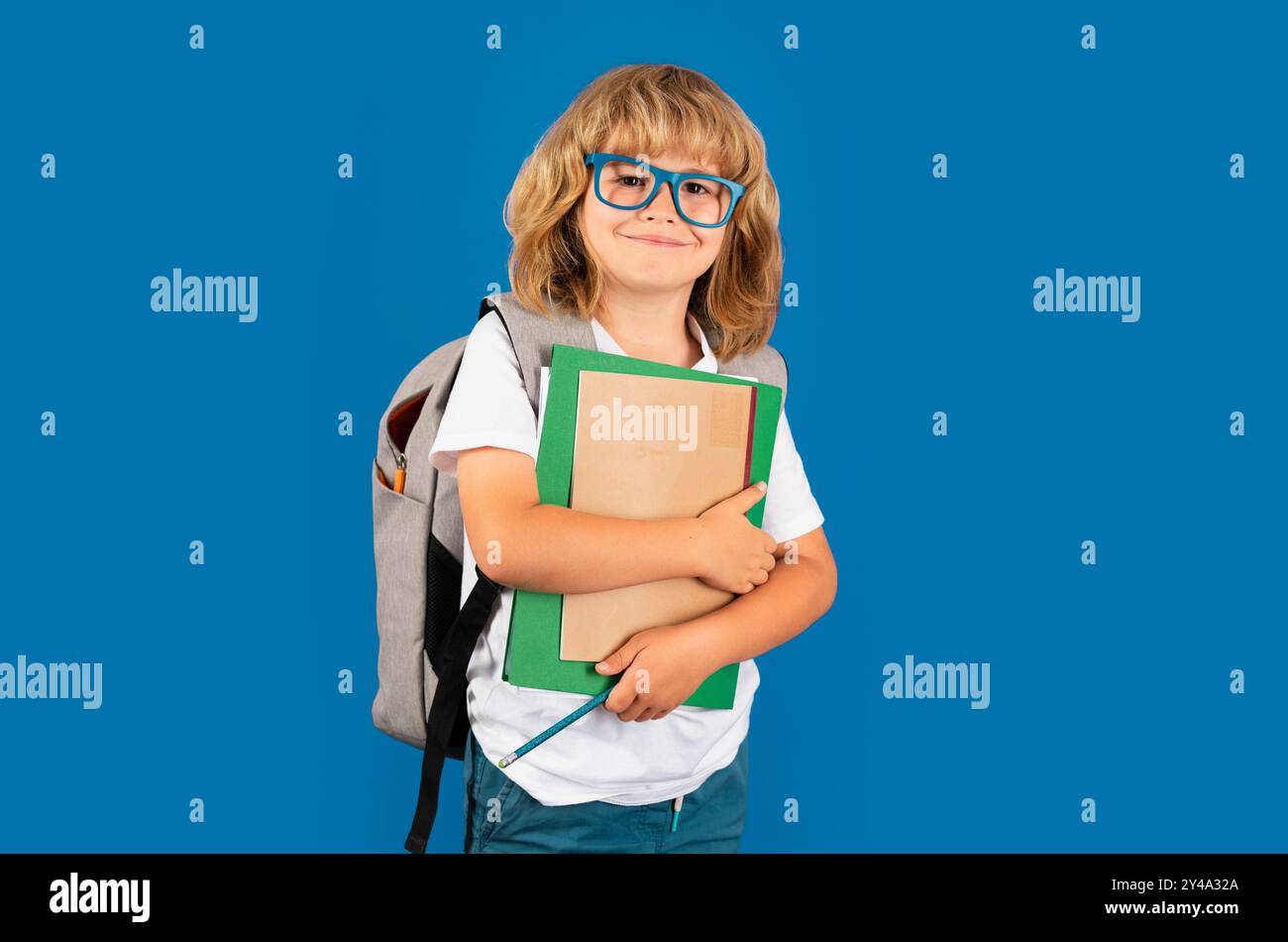 Portrait of pupil student hold book on blue isolated studio background ...