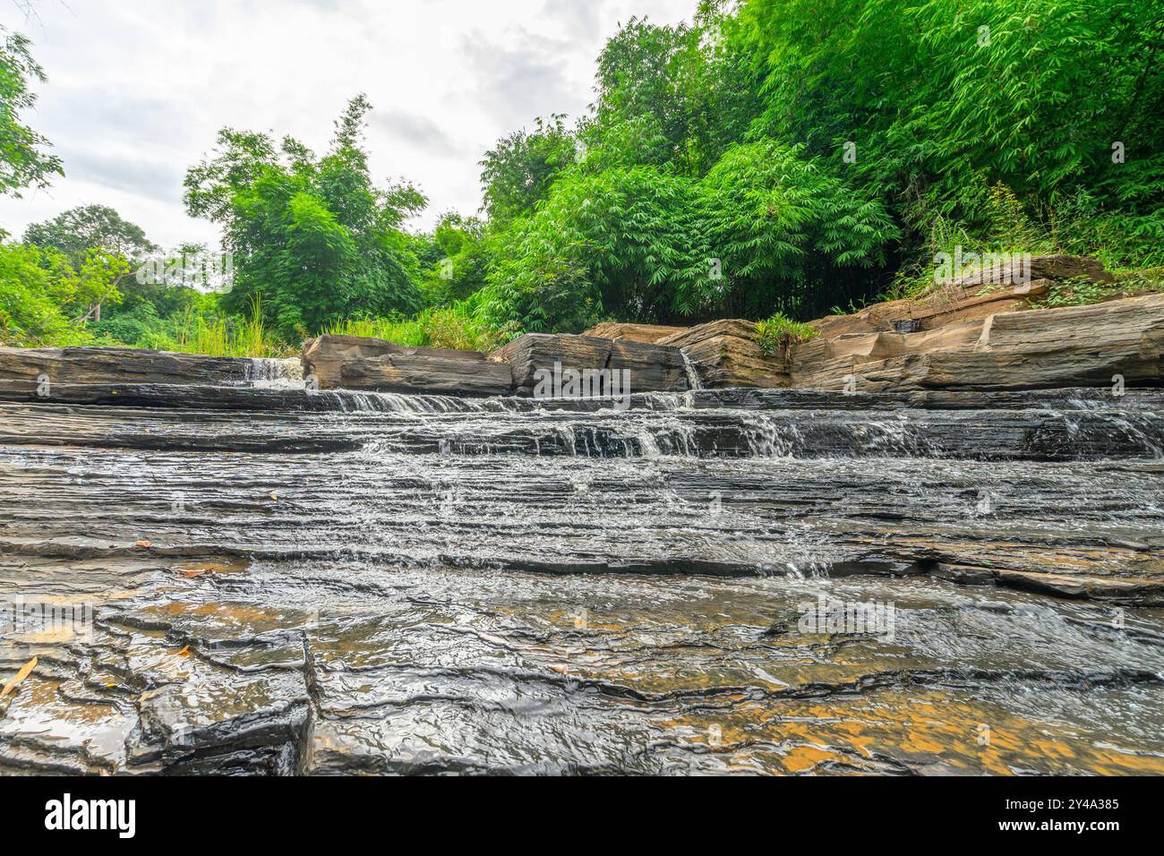 Waterfall called Tat Yai Waterfall with rock layer and green forest ...