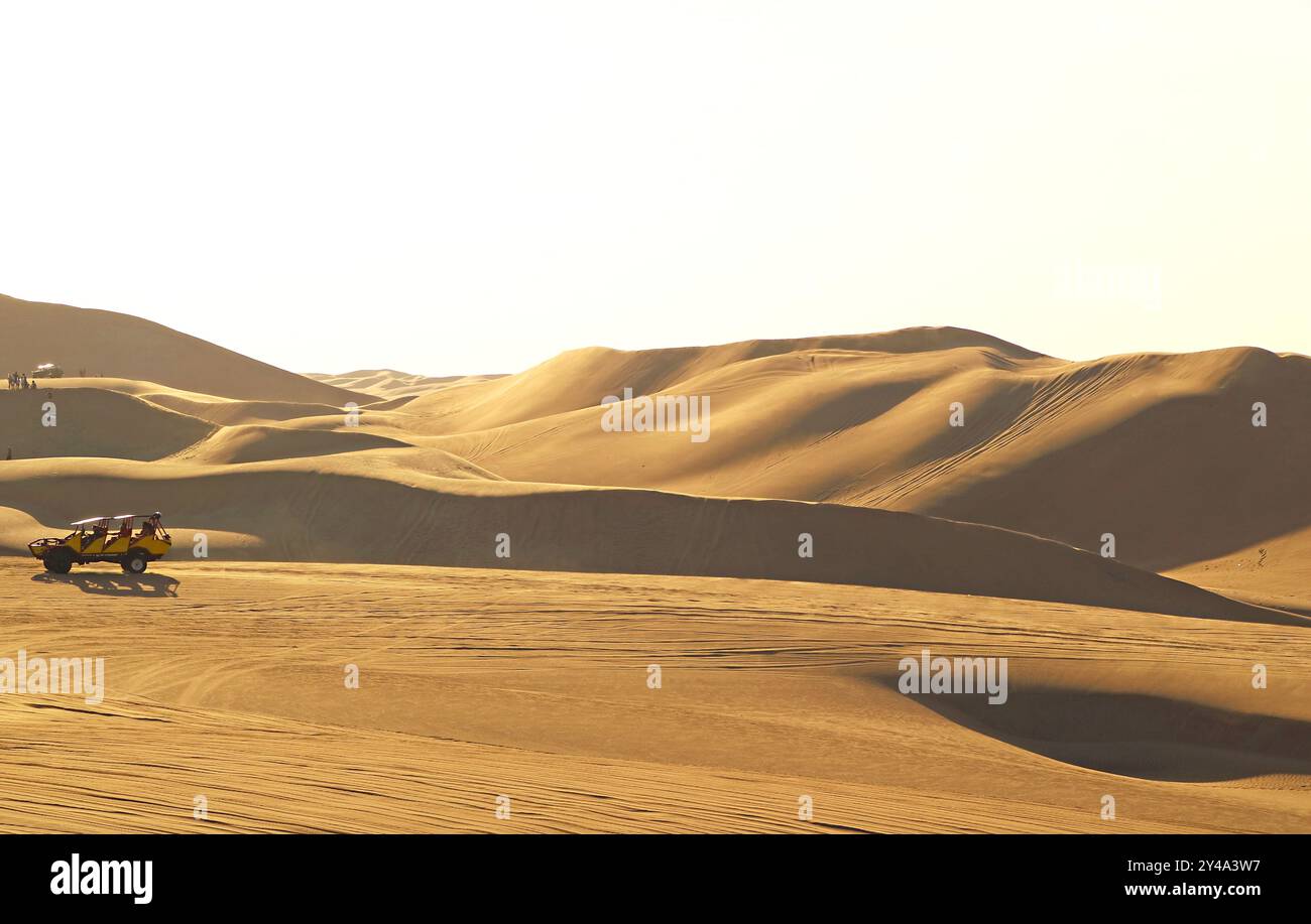 Dune buggy on the vast desert of Huacachina with group of people enjoy ...