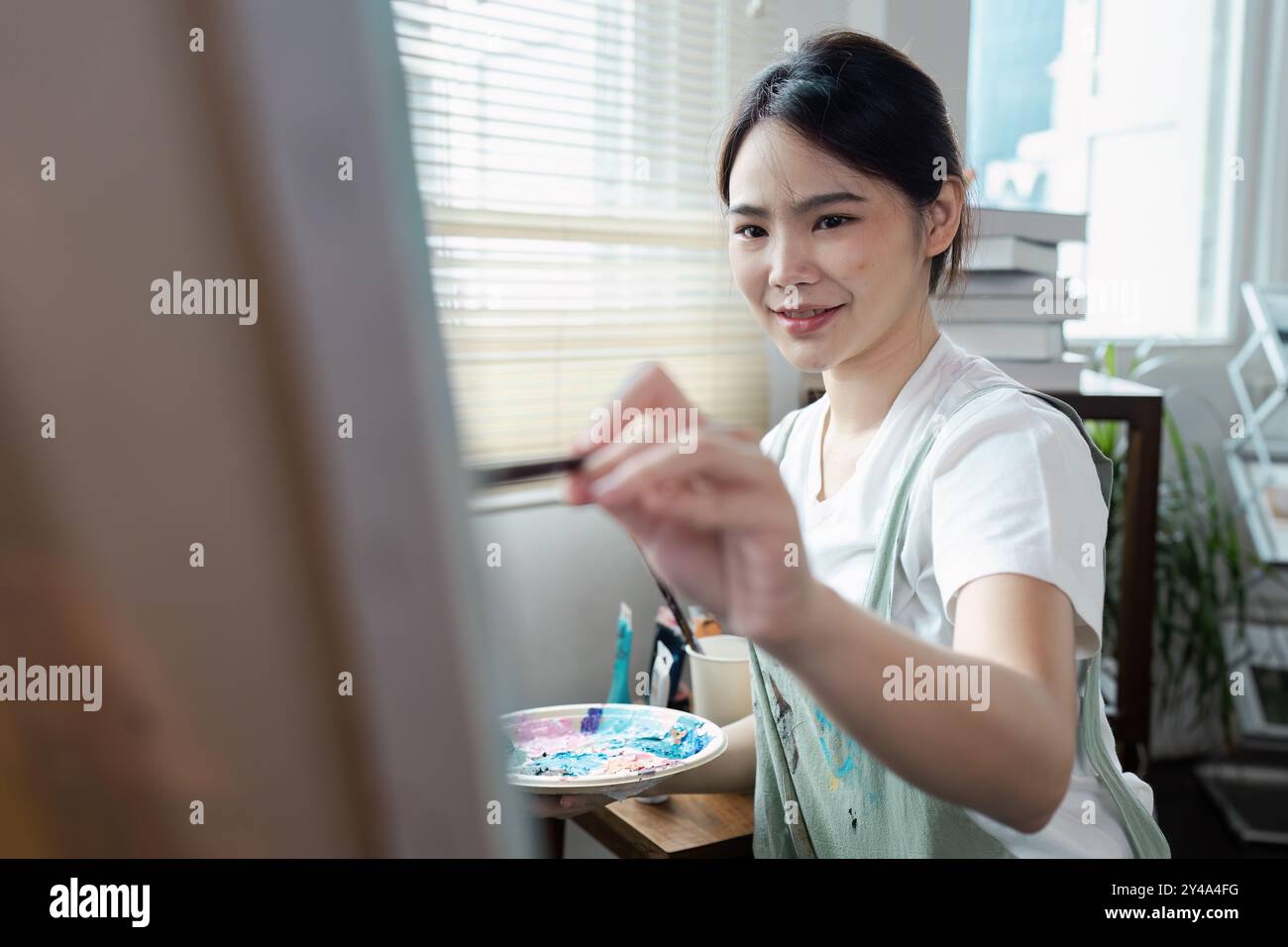 Young Woman Artist Painting on Canvas in Bright Studio with Natural ...