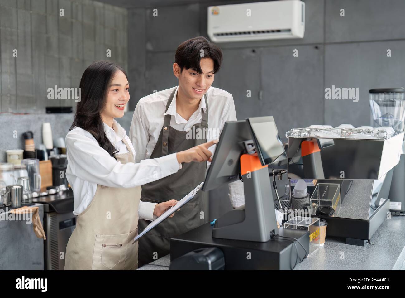Young Baristas Working Together at a Modern Coffee Shop Counter with a ...