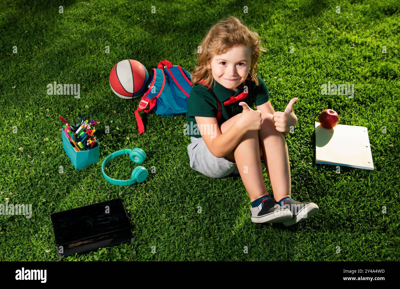 Schoolboy with school supplies in nature. Child remote learning ...