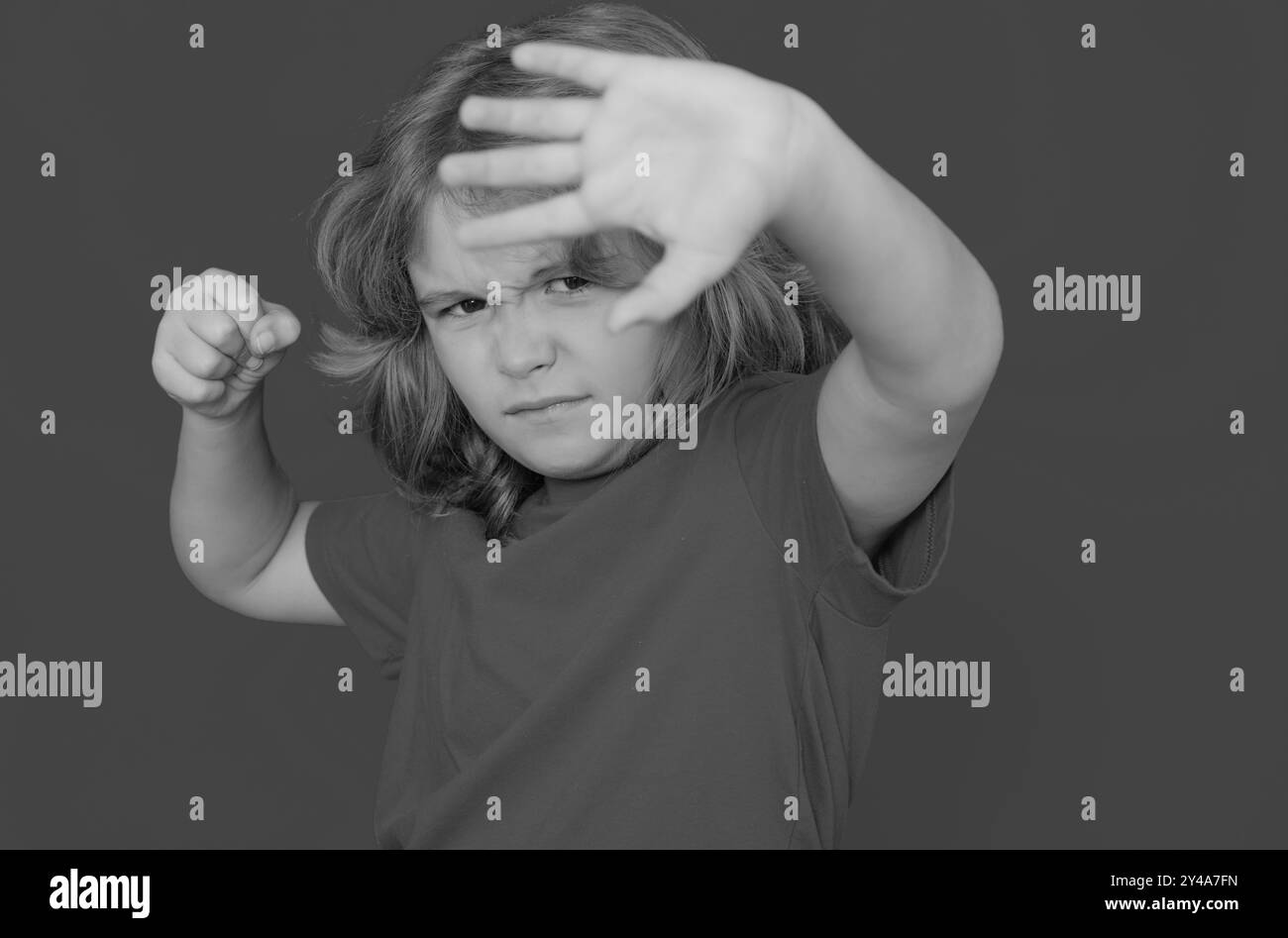 Andry child in red t-shirt making stop gesture on isolated studio ...